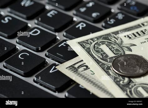 Dollar Bill And Coin On Computer Keyboard Stock Photo Alamy