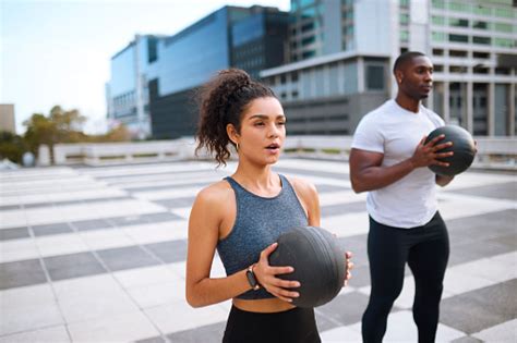 건물 테라스의 체크 무늬 바닥에서 메디신 볼로 훈련에 초점을 맞춘 다인종 운동 선수 커플의 초상화 20 24세에 대한 스톡 사진 및 기타 이미지 Istock