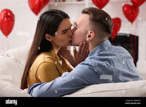 Lovely Couple Kissing On Sofa Indoors Valentines Day Celebration