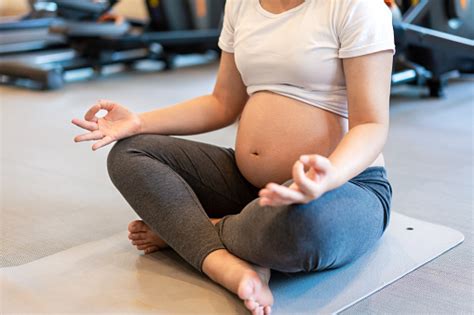 요가룸의 피트니스 센터에서 활동적인 임산부 운동을 합니다 임신 한 배에 아기를 들고 젊은 기대 어머니 출산 전 관리 및 여성 임신 개념 건강한 생활방식에 대한 스톡 사진 및