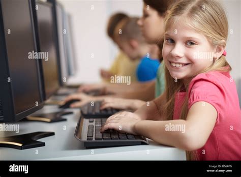 Portrait Of Lovely Schoolgirl Looking At Camera While Typing On