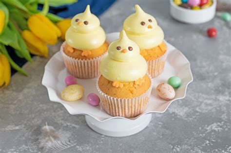 귀여운 부활절 병아리 컵 케이크 흰색 나무 배경에 신선한 꽃이 있는 흰색 스탠드에 버터크림을 곁들인 바닐라 컵케이크 공간을 복사합니다 부활제에 대한 스톡 사진 및 기타