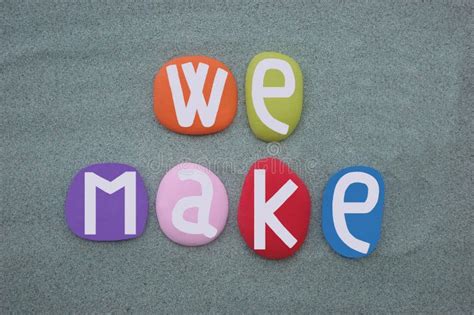 We Make Creative Slogan Composed With Multi Colored Stone Letters Over Green Sand Stock Image