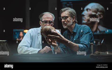 Two Archaeologists Take Measurements Of Prehistoric Human Skull Conduct Scientific Research