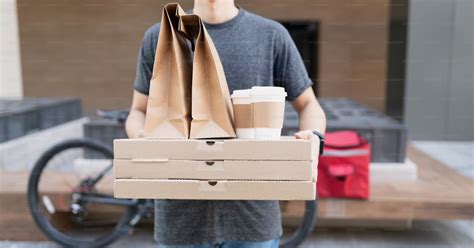 음식 배달원이 보도에 서서 소포를 나르는 모습 사진 Unsplash의 배달원 이미지