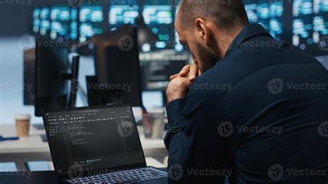 computer scientist overseeing data center servers typing code on