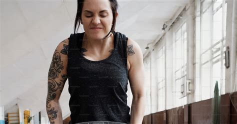 체육관에서 크로스 트레이닝을 하는 동안 큰 무거운 타이어를 뒤집는 문신을 한 팔을 가진 단호한 운동 여성 사진 Unsplash의 체육관 여자 이미지