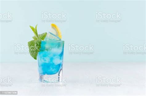레몬 슬라이스 얼음 조각 흰색 나무 테이블 파스텔 녹색 배경에 젖은 유리잔에 민트와 여름 신선한 블루 퀴 라 소 칵테일 칵테일에 대한 스톡 사진 및 기타 이미지 Istock