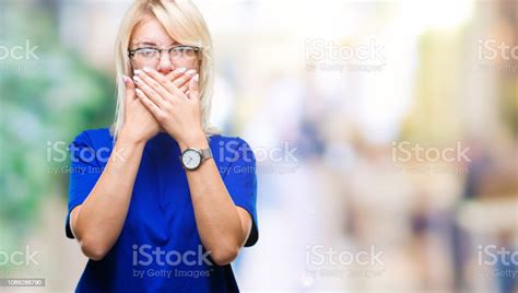 젊은 아름 다운 금발 여자 입 실수에 대 한 손으로 다루는 충격된 절연된 배경 위에 안경 착용 비밀 개념입니다 가리기에 대한 스톡 사진 및 기타 이미지 Istock