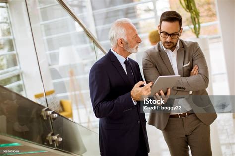 수석 사업가 고 사무실에서 디지털 태블릿에 주니어 파트너에 게 뭔가 보여주는 기업 비즈니스에 대한 스톡 사진 및 기타 이미지 기업 비즈니스 기업가 남자 Istock