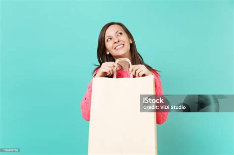 꿈꾸는 듯한 젊은 여자 니트 핑크 스웨터 찾고 블루 터키석 벽 배경에 고립 된 텍스트 비문 작성 판매 쇼핑 가방을 들고 사람들의 라이프 스타일 개념입니다 복사 공간을 비웃는