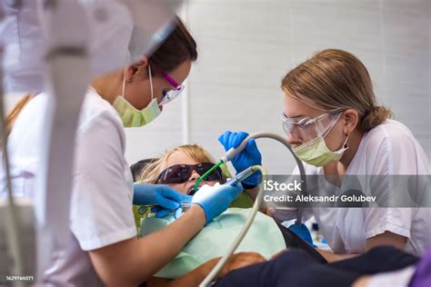 치과 진료실에서 치아 치료를 하는 치과의사 귀여운 꼬마 소녀 라이프스타일 병원에서 56세 어린 소녀를 치료하는 치과의사 의사 어린이 의료 치과의 개념입니다 광고문안 공간