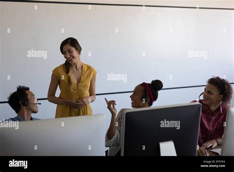 Executives interacting with each other in office Stock Photo - Alamy
