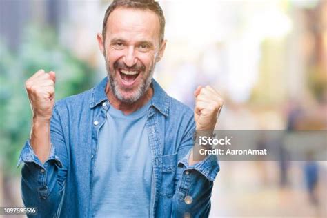 축 하 하는 고립 된 배경 위에 중 년 노인의 수석 남자 놀라게 무기 제기와 성공을 위한 깜짝 놀라게 고 눈을 엽니다 우승자 개념입니다 긍정적인 감정 표현에 대한 스톡 사진