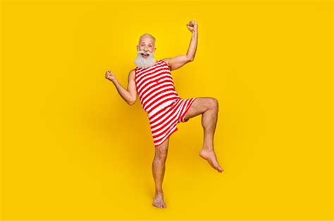 쾌활한 운이 좋은 노인 남자가 옷을 입고 줄무늬 빨간 수영복 비명을 지르는 예 상승 주먹 고립 된 노란색 배경의 전체 길이 사진 55 59세에 대한 스톡 사진 및 기타