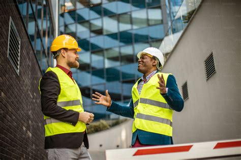 건설 현장에서 건축가 동료와 건물의 구조에 대해 논의하는 엔지니어 사진 Unsplash의 흑인 남성 이미지