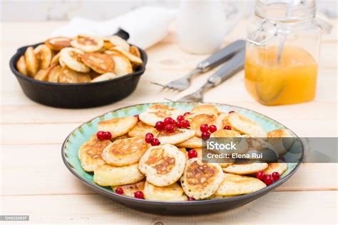 트렌드 아침 식사 접시에 빨간 건포도가있는 네덜란드 미니 팬케이크와 나무 테이블에 팬이 있습니다 0명에 대한 스톡 사진 및 기타 이미지 Istock