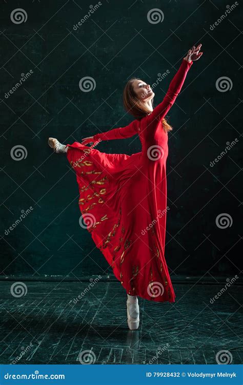 Балерина представляя в ботинках Pointe на черном деревянном павильоне ...