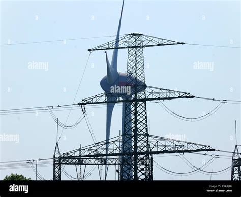 A Photo Of A Wind Turbine And A High Voltage Mast Symbolizes