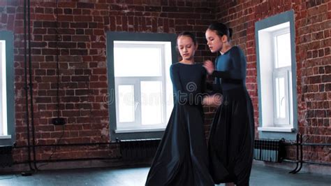 Two Ballerina Girls Dancing In Long Dark Costumes On Training In The