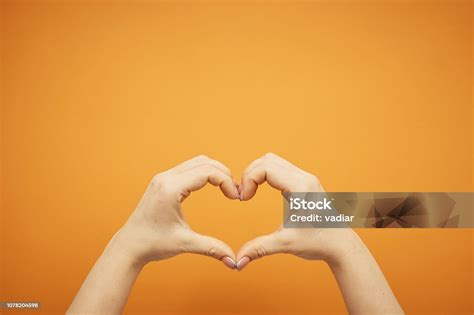 제스처 여성의 손을 잡고 오렌지 배경에 고립 된 그의 손가락에서 심장 손에 대한 스톡 사진 및 기타 이미지 손 개념 동의 Istock