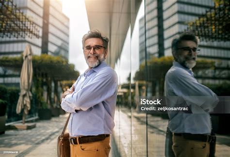 거리에 서서 스마트 폰을 사용하여 의사 소통하는 잘생긴 노인 사업가 배경에 현대 건물 Brand Name Smart Phone에 대한 스톡 사진 및 기타 이미지