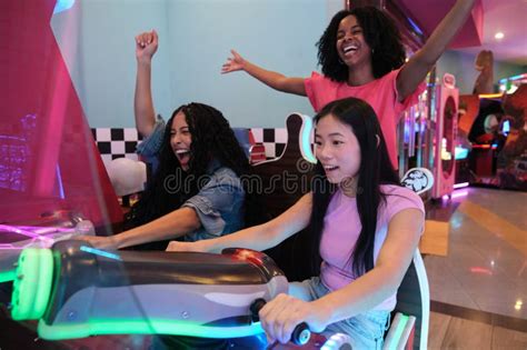 Excited Female Friends Playing Arcade Racing Game Together Stock Image Image Of Asian Girls