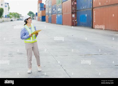 Asian Woman Happy Dock Worker Control Loading Containers Cargo At Shipyard Marine And Carrier