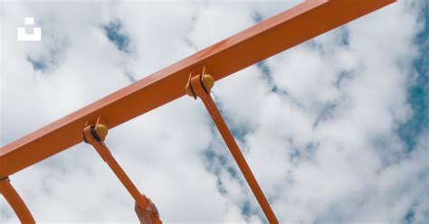 검은 셔츠와 파란색 데님 청바지를 입은 소녀는 파란색과 흰색 아래에서 주황색 스윙을 타고 있습니다 사진 Unsplash의 무료 사람의 이미지