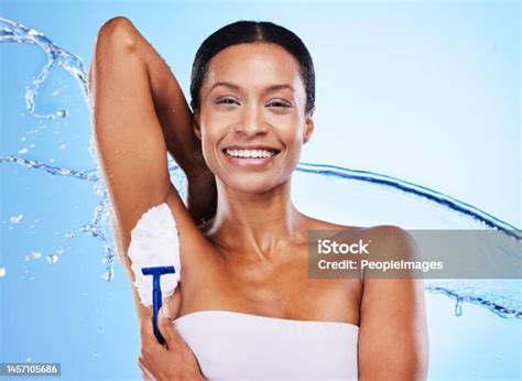 흑인 여성 크림과 면도기로 겨드랑이 면도 몸단장을 위한 아름다움 파란색 스튜디오 배경의 샤워 물 튀김 위생 거품 제품 깨끗 하 고 스킨 케어 초상화 화장품 제모 30 34