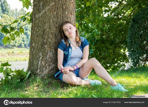 Girl Sitting Against Tree