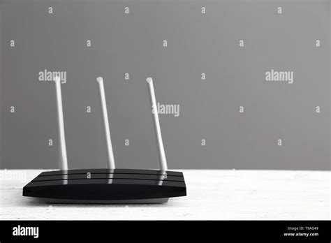 Modern Wi Fi Router On Light Table Against Grey Background Stock Photo Alamy
