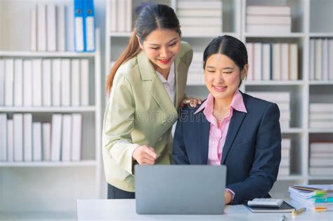 Two Successful Asian Businesswomen Working With Financial Data Graph