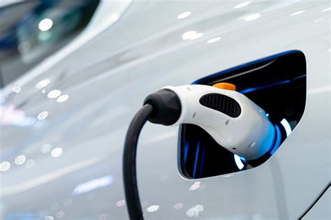 전기 플러그가 전기 자동차에 연결되어 있고 전기 자동차가 충전 중입니다 전기 자동차 대체 연료 차량에 대한 스톡 사진 및 기타 이미지 전기 자동차 대체 연료 차량 0명