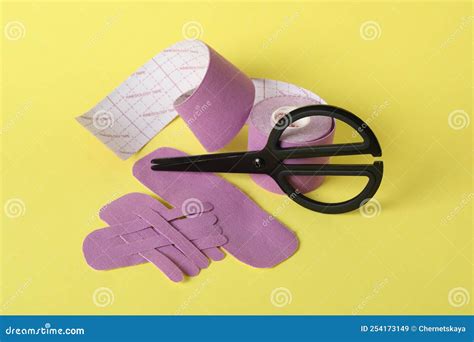 Scissors Bright Kinesio Tape Roll And Pieces On Yellow Background