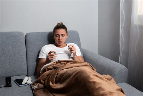 독감 여자가 감기에 걸렸다 티슈에 재채기 두통 바이러스 의학 감기에 걸린 젊은 여자가 손수건으로 코를 풀었다 소파에 앉아 두통을