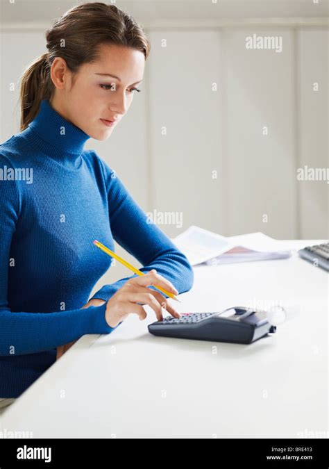 Woman Using Calculator In Office Stock Photo Alamy