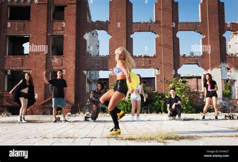 Young Girl Hip Hop Dancing In An Urban Square With Her Friends
