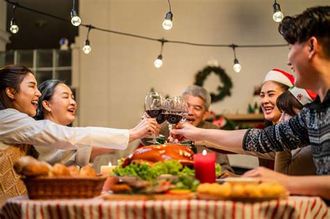 집에서 함께 크리스마스 파티를 축하하는 아시아 사랑스러운 가족 저녁 식사를하는 매력적인 부모와 친척 휴일 추수 감사절 식탁에서 크리스마스 이브를 축하하기 위해 와인 한 잔을