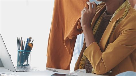 Caucasian Female Fashion Designer Works In Studio By Idea Drawing Sketches With Digital Tablet