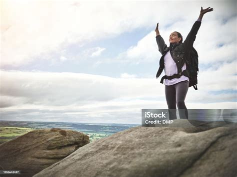 하이킹 도중 팔을 들어 올린 채 언덕에 홀로 서 있는 매력적인 젊은 여성의 사진 20 29세에 대한 스톡 사진 및 기타 이미지 20 29세 40 44세 가방 Istock