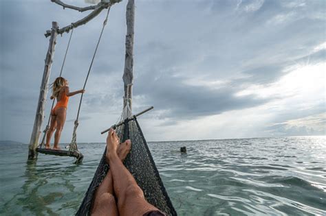 젊은 커플 바다 아름 다운 전원적인 풍경에 의해 해변에 스윙 사람들이는 로맨스 휴가 개념 여행 바다 해먹에 인간과 바다 스윙에