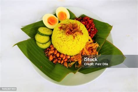 나시 쿠닝 또는 노란 쌀 또는 Tumeric 쌀은 심황으로 조리 된 쌀 코코넛 밀크 및 계란 닭고기 땅콩 칠리 소스 얇게 썬 오이와 함께 제공되는 향신료로 만든 아시아의