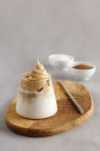 한국 음료 회색 배경에 우유와 유리에 수제 달고나 커피 트렌디한 푹신한 크리미 한 휘핑 커피 나무 스탠드 0명에 대한 스톡 사진