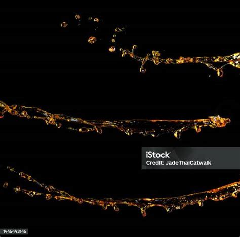 오렌지 레몬 주스 또는 오일 윤활유 스플래시 액체 골드 노란색 음료 방울 선 형태의 과일 음료 물 요소 신선한 튀고 흐르는 제트기 검은 배경 격리 된 동결 동작 가솔린에