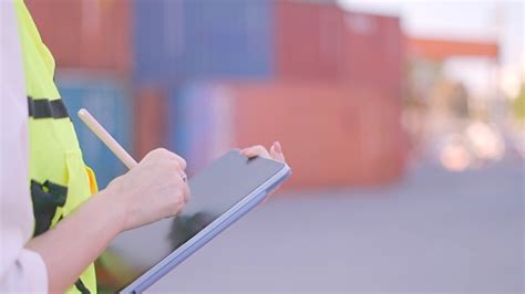 닫기 안전 조끼를 입은 여성 엔지니어 또는 기술자 또는 작업자의 손 적재 컨테이너 야드에서 작업하기 위해 서있는화물 컨테이너를