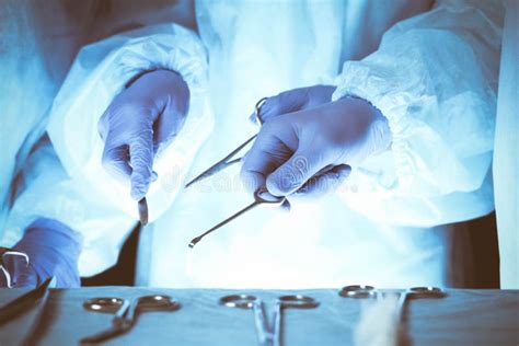 Surgeons Hands Holding Surgical Scissors And Passing Surgical Equipment
