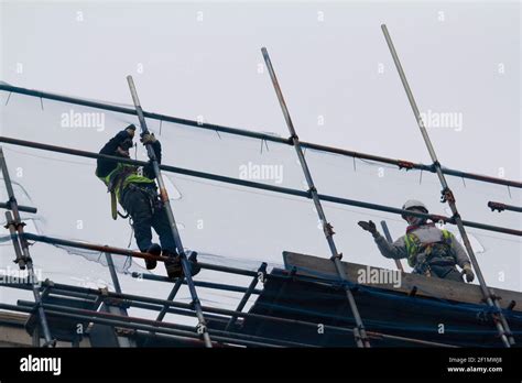 Scaffolder Erecting Scaffold Scaffolding On Premises In Tottenham Court Road London Stock Photo