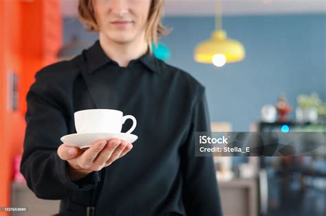 카페 숍에서 뜨거운 커피 한 잔을 들고 바리스타 손을 닫고 커피 숍 카운터 바에서 고객에게 커피를 제공하는 웨이터 직원 카메라에 음료 음료를 주는 남자 25 29세에 대한