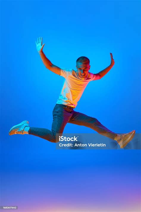 승리한 기뻐하는 남자의 네온 불빛 초상화는 별 모양으로 손을 들고 기쁨을 외치고 승리의 성공을 축하하고 감동적인 감정을 느낀다